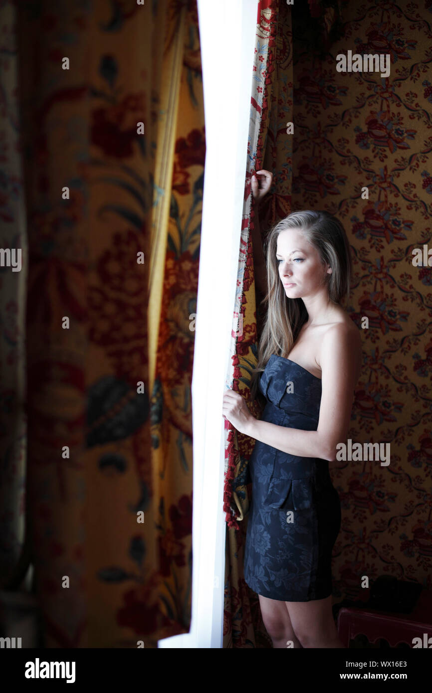 Beautiful woman look in window Stock Photo - Alamy