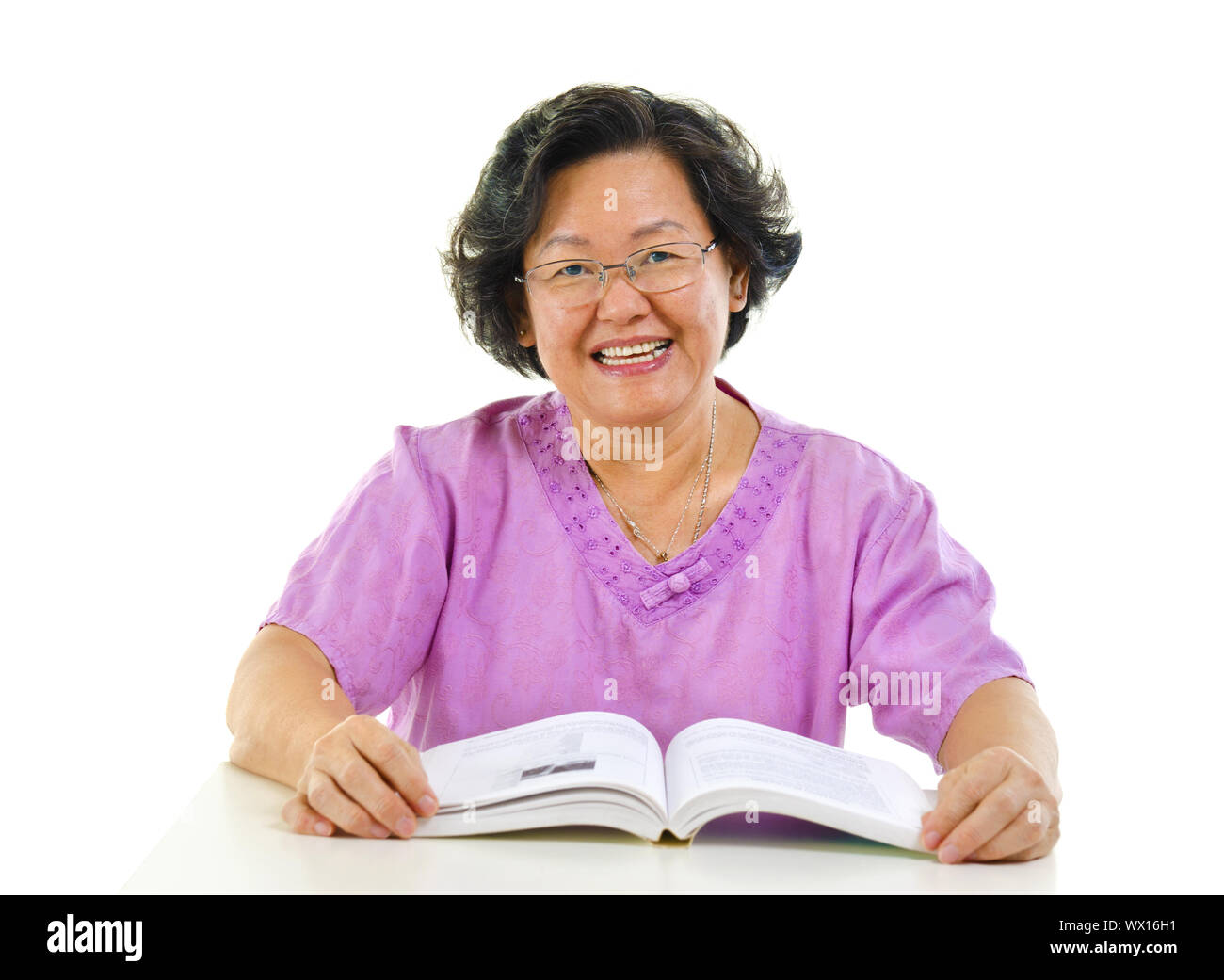 Asian senior woman reading book over white background Stock Photo - Alamy