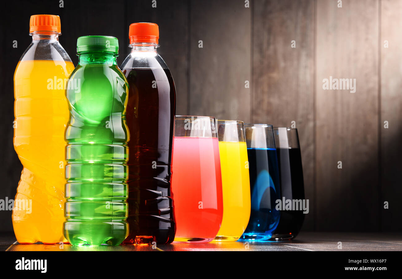 Glasses and bottles of assorted carbonated soft drinks in variety of ...