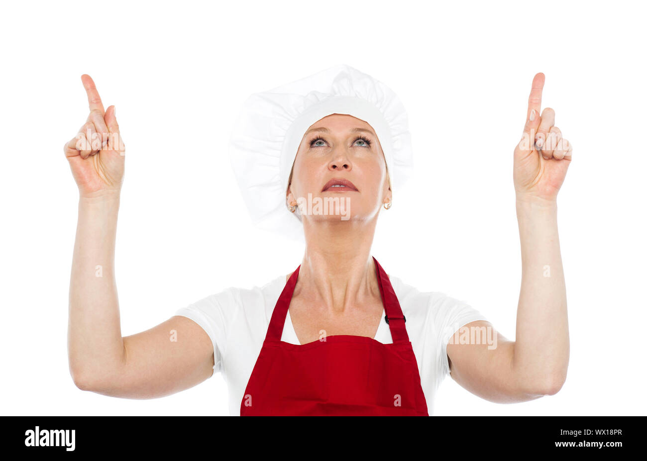 Isolated female chef in uniform pointing upwards against white ...