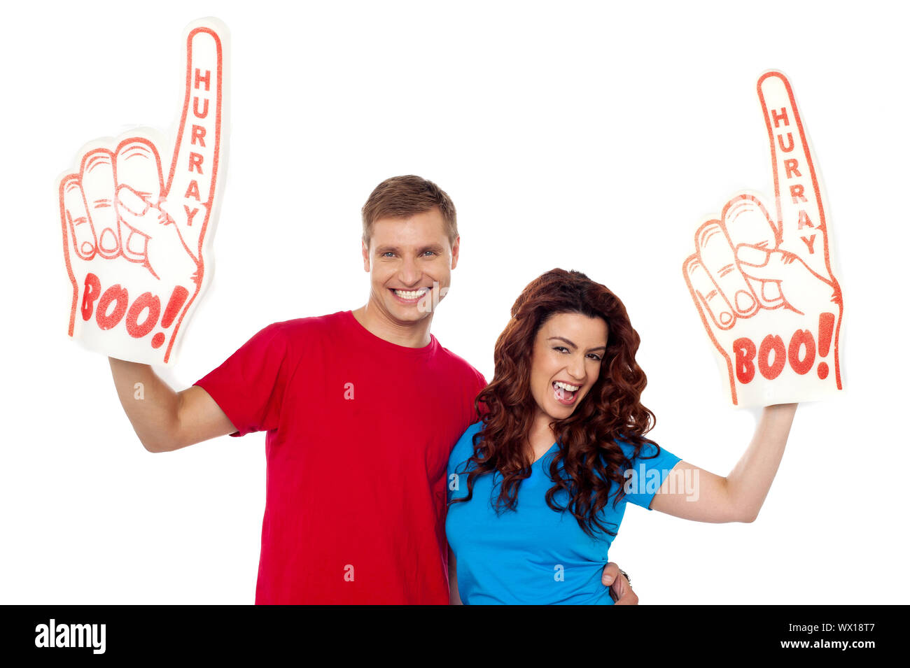 Young couple showing boo hurray foam hand to camera, excited couple ...