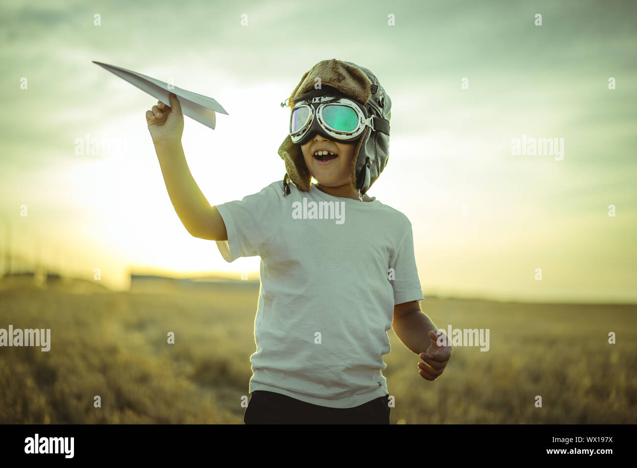 boy at sunset playing at being aviator, he wears pilot glasses of ...