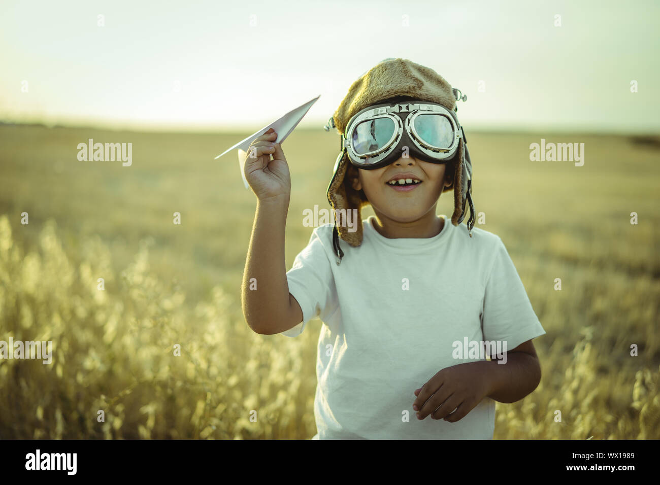 boy at sunset playing at being aviator, he wears pilot glasses of ...