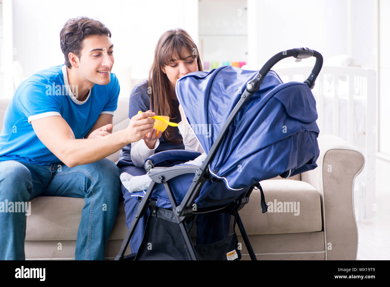 Young parents with their newborn baby in baby pram sitting on th Stock ...