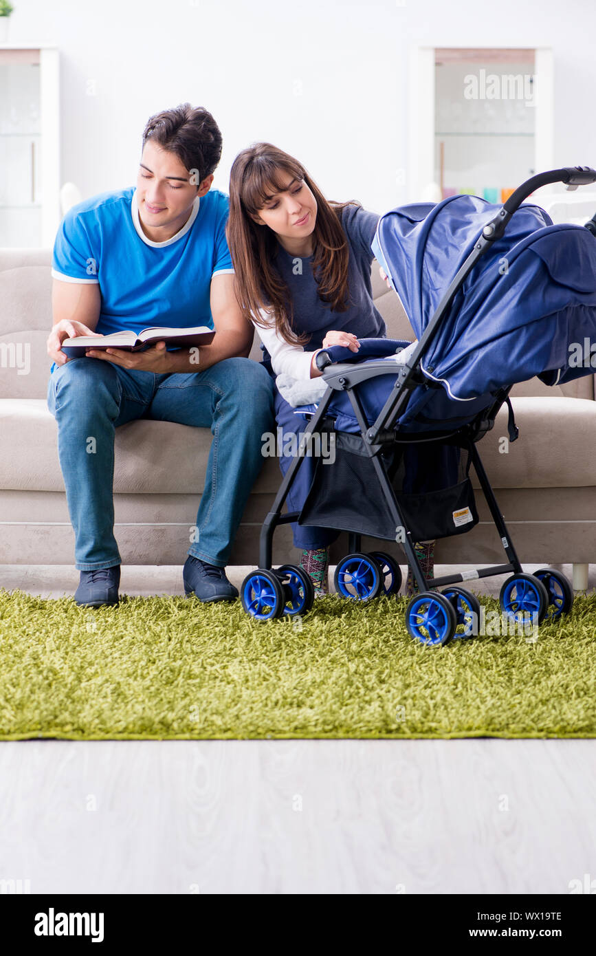 Young parents with their newborn baby in baby pram sitting on th Stock ...