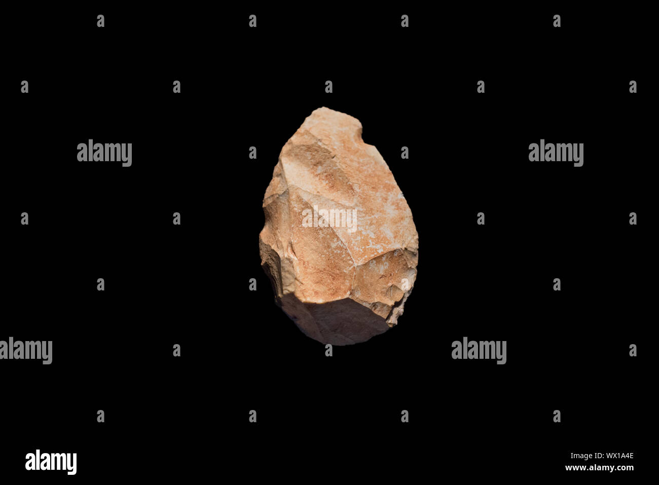 Prehistoric human tool, sandstone cleaver on black isolated background ...