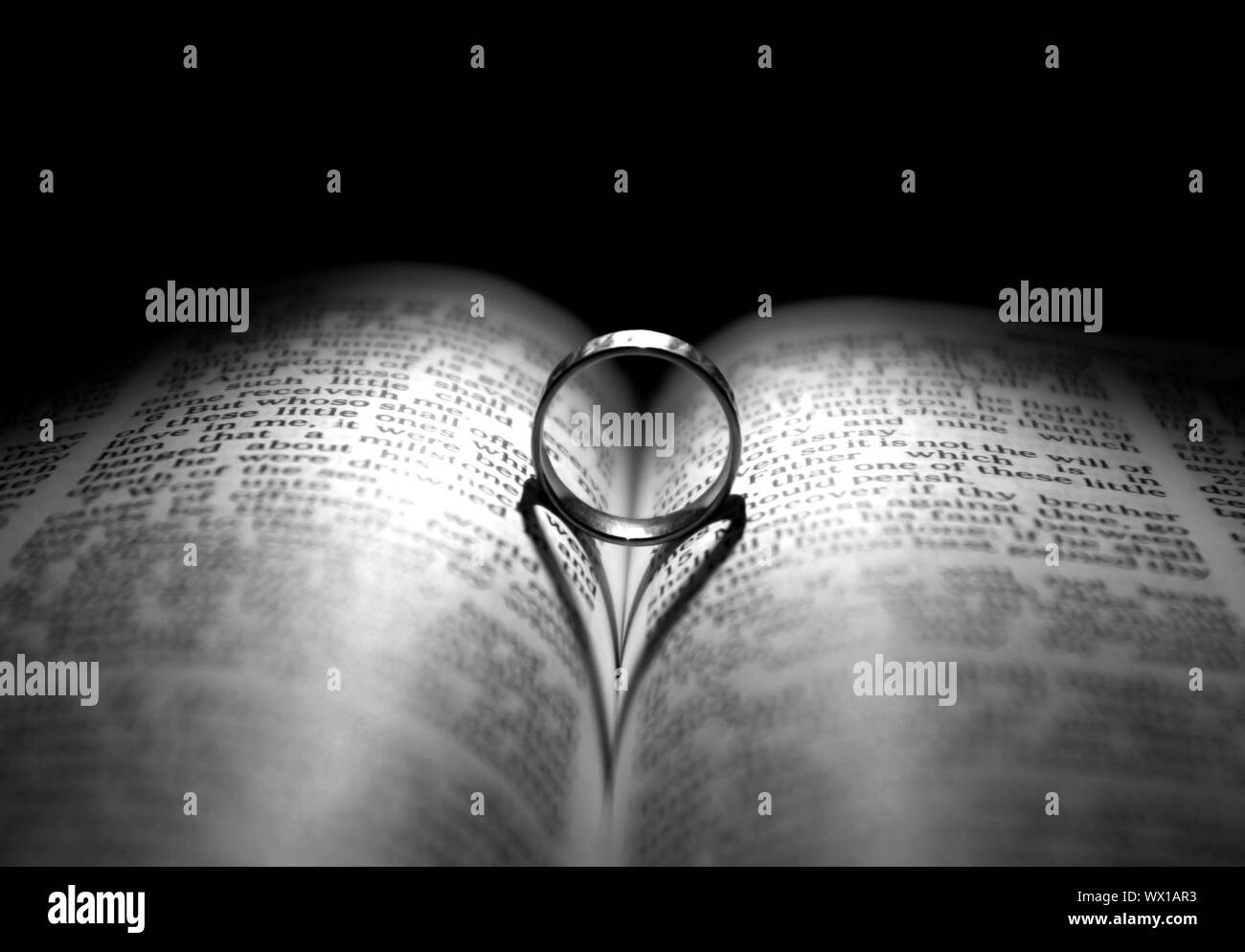 Wedding Ring and heart shaped shadow over a Bible Stock Photo - Alamy