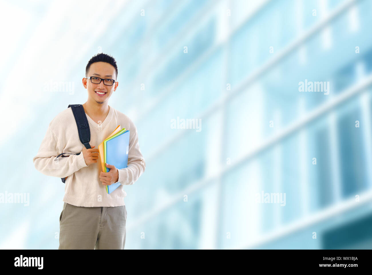 Good looking Asian university student standing at campus, modern ...