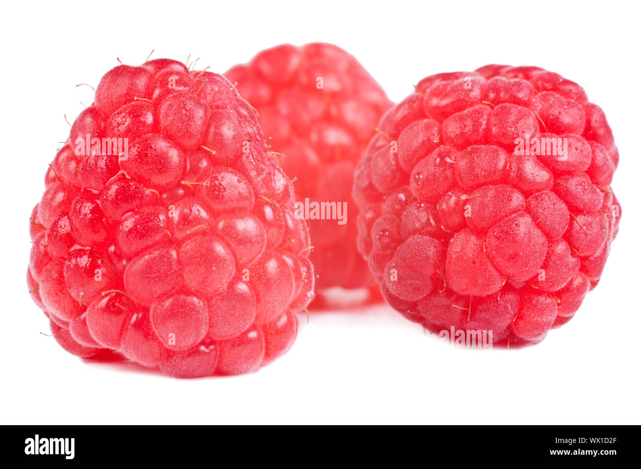 Group of three red raspberries on a white background Stock Photo - Alamy