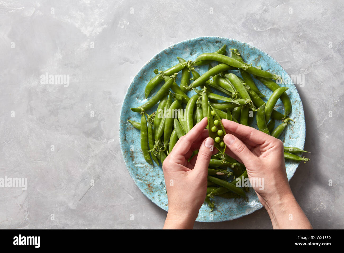 Female hands open young pea sticks. Natural green vegetables for ...