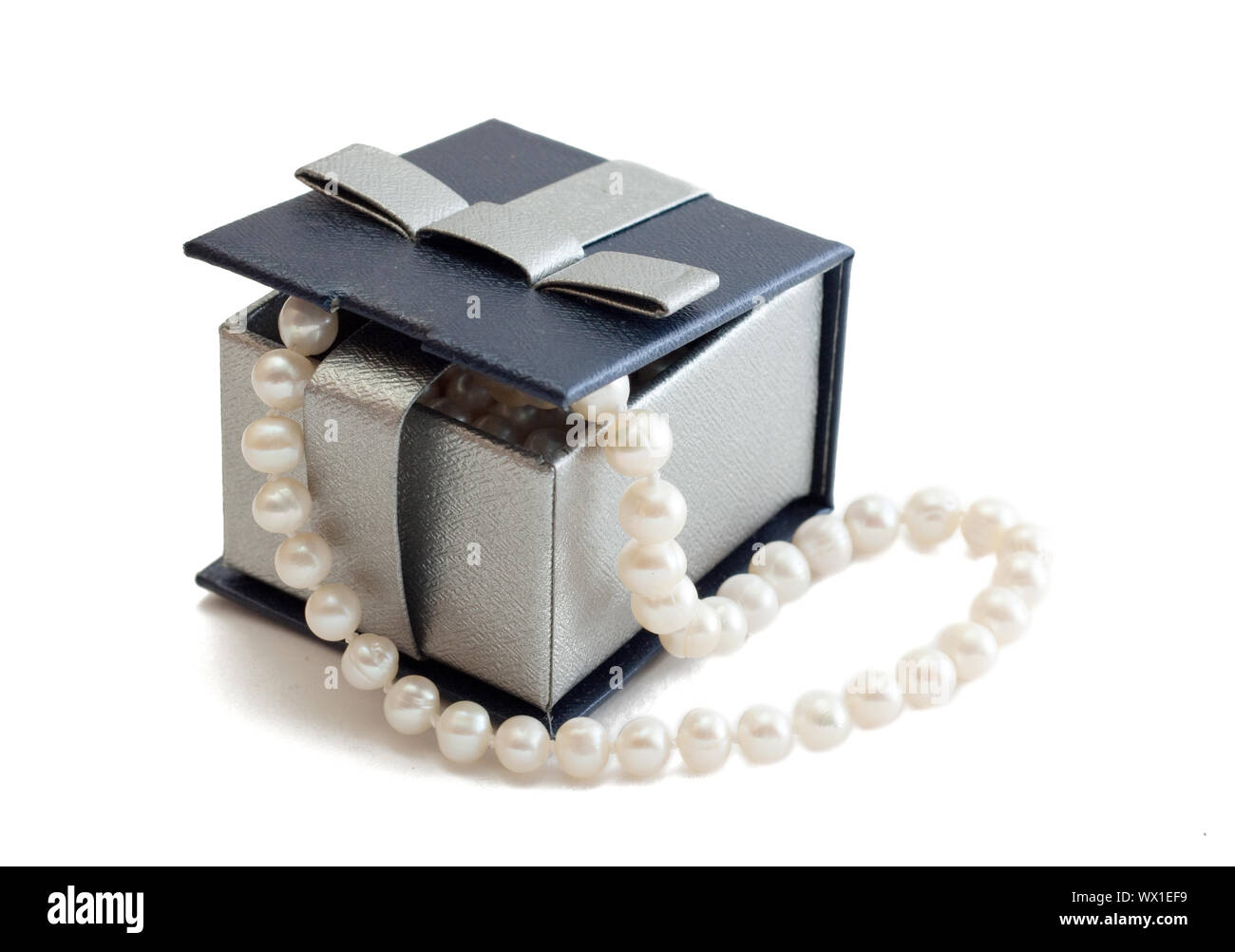 A string of pearls in a box on white background Stock Photo - Alamy