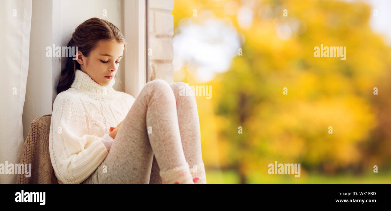 sad girl sitting on sill at home window in autumn Stock Photo - Alamy