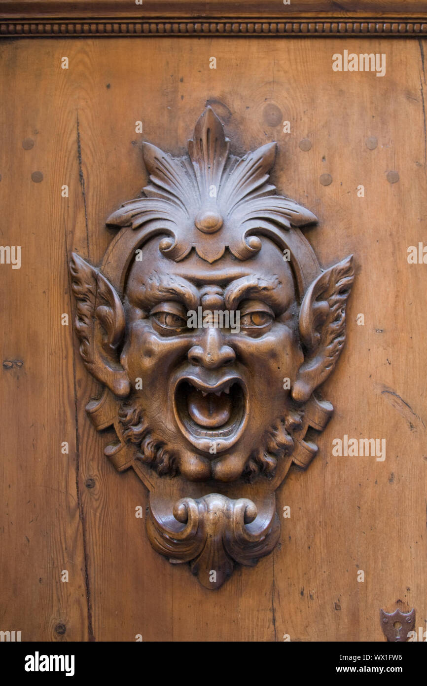 Carved gargoyle adorning a wooden door in Siena, Italy Stock Photo - Alamy