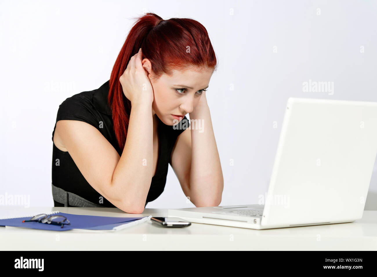 Professional woman showing concern at work using her laptop Stock Photo ...