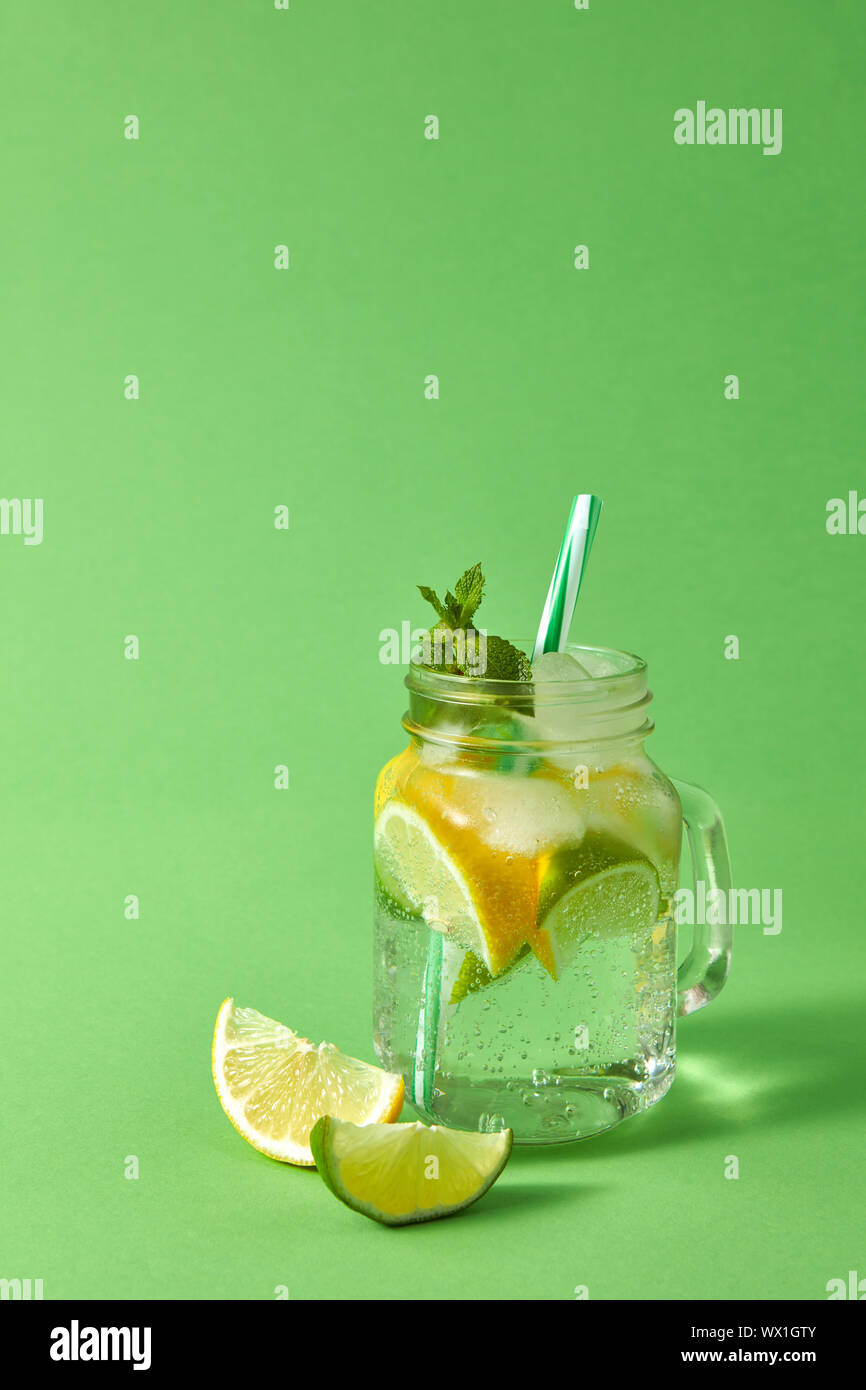 Mason jar with homemade sparkling lemonade with ice, slices of lime and ...