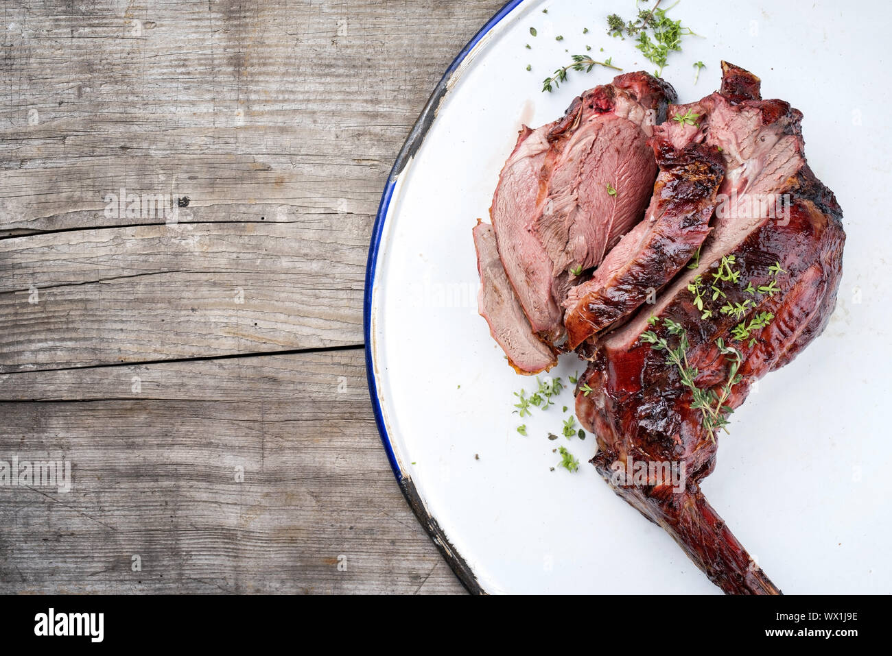Marinated barbecue aged leg of venison with bone sliced as top view on ...