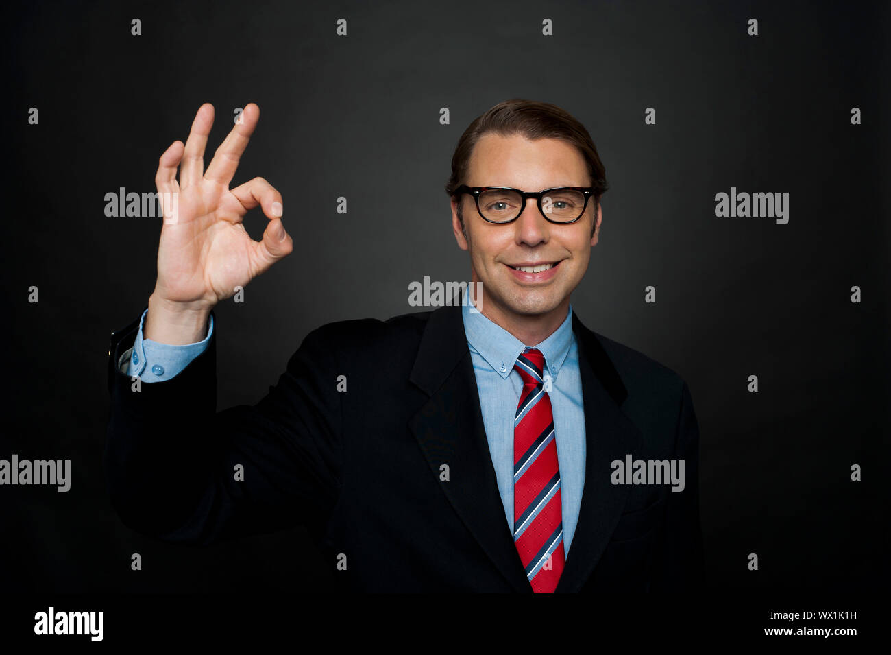Manager showing okay sign to camera, good work. Isolated on black ...