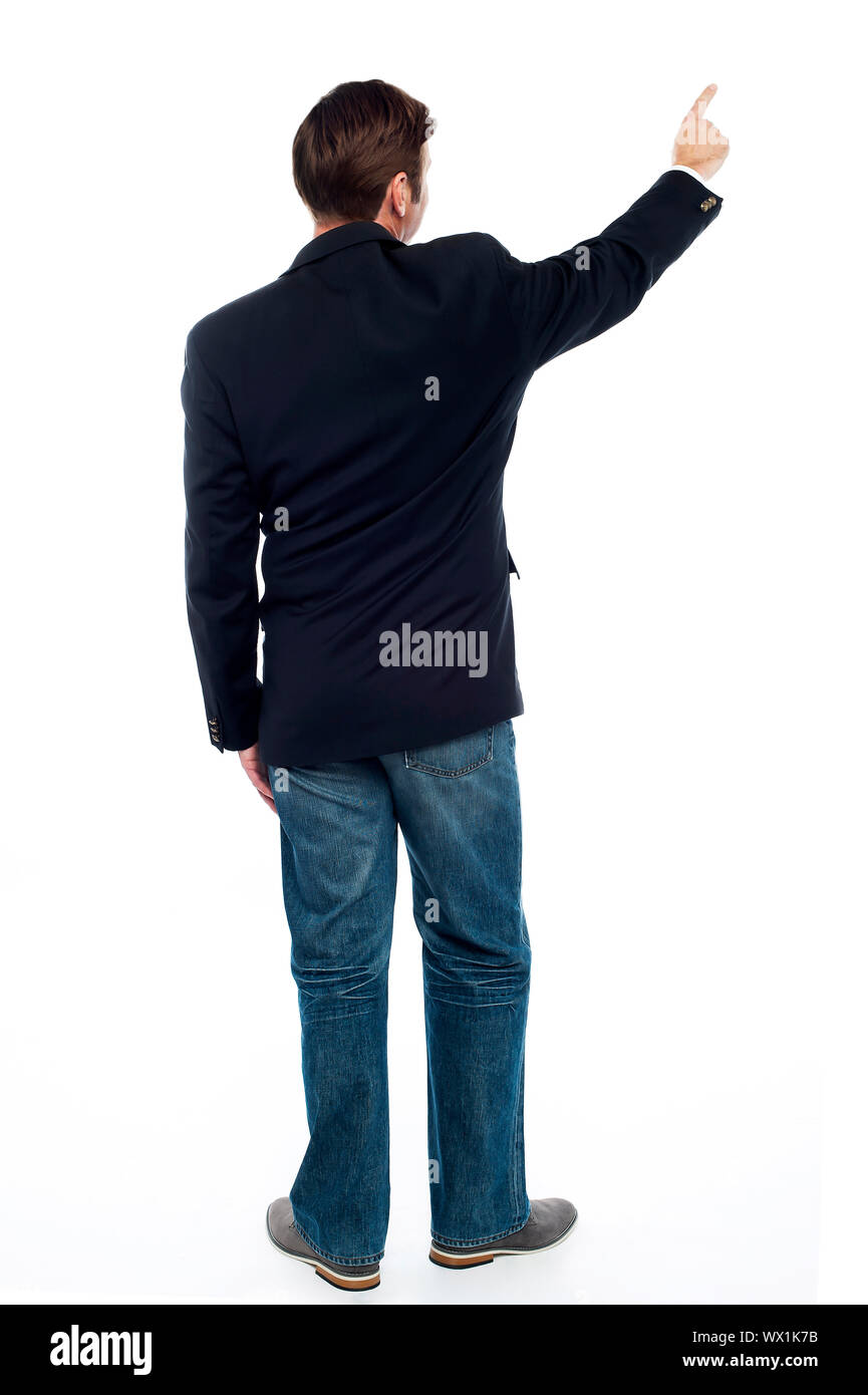 Back pose casual guy pointing at the copy space area isolated against ...