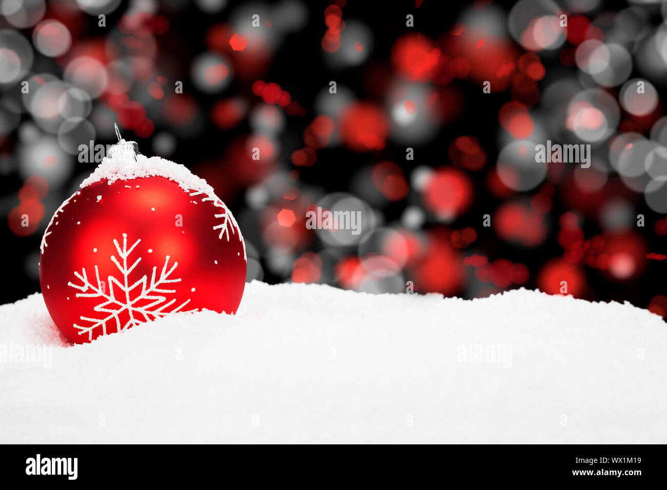 red christmas ball in snow with abstract background lights Stock Photo ...