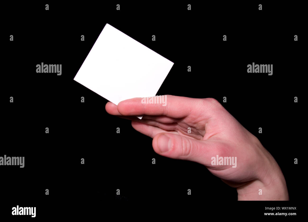 Blank card in hand isolated on black background Stock Photo - Alamy