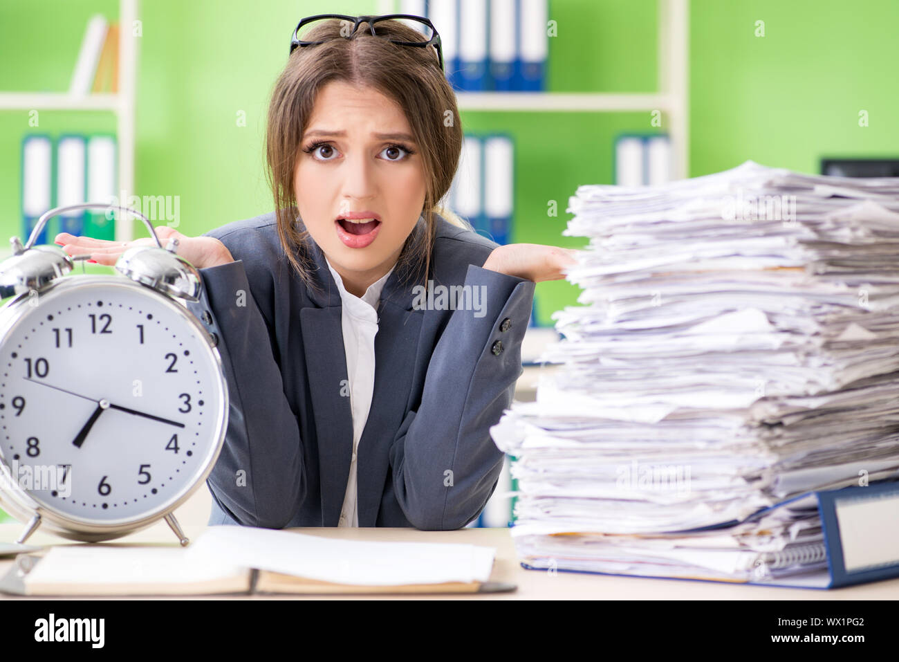 Young female employee very busy with ongoing paperwork in time m Stock ...