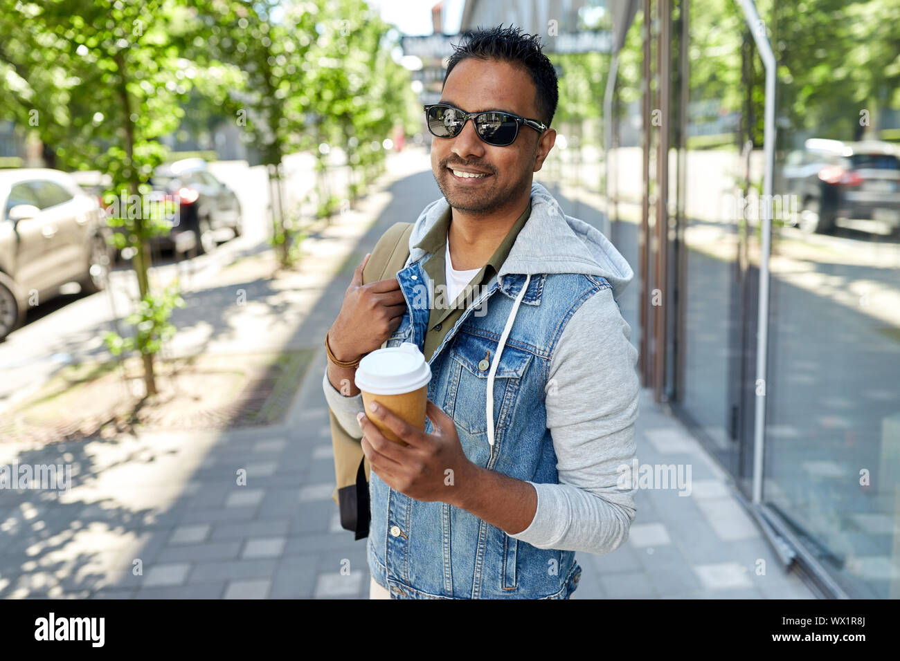 indian man with bag and takeaway coffee in city Stock Photo - Alamy