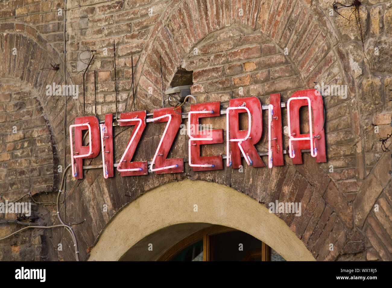 Pink neon pizzeria sign outside an Italian restaurant Stock Photo - Alamy