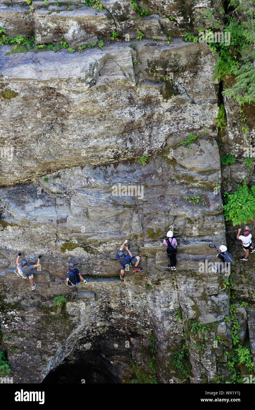 People on the cliffs on the via ferrata at Canyon Ste Anne, Quebec ...