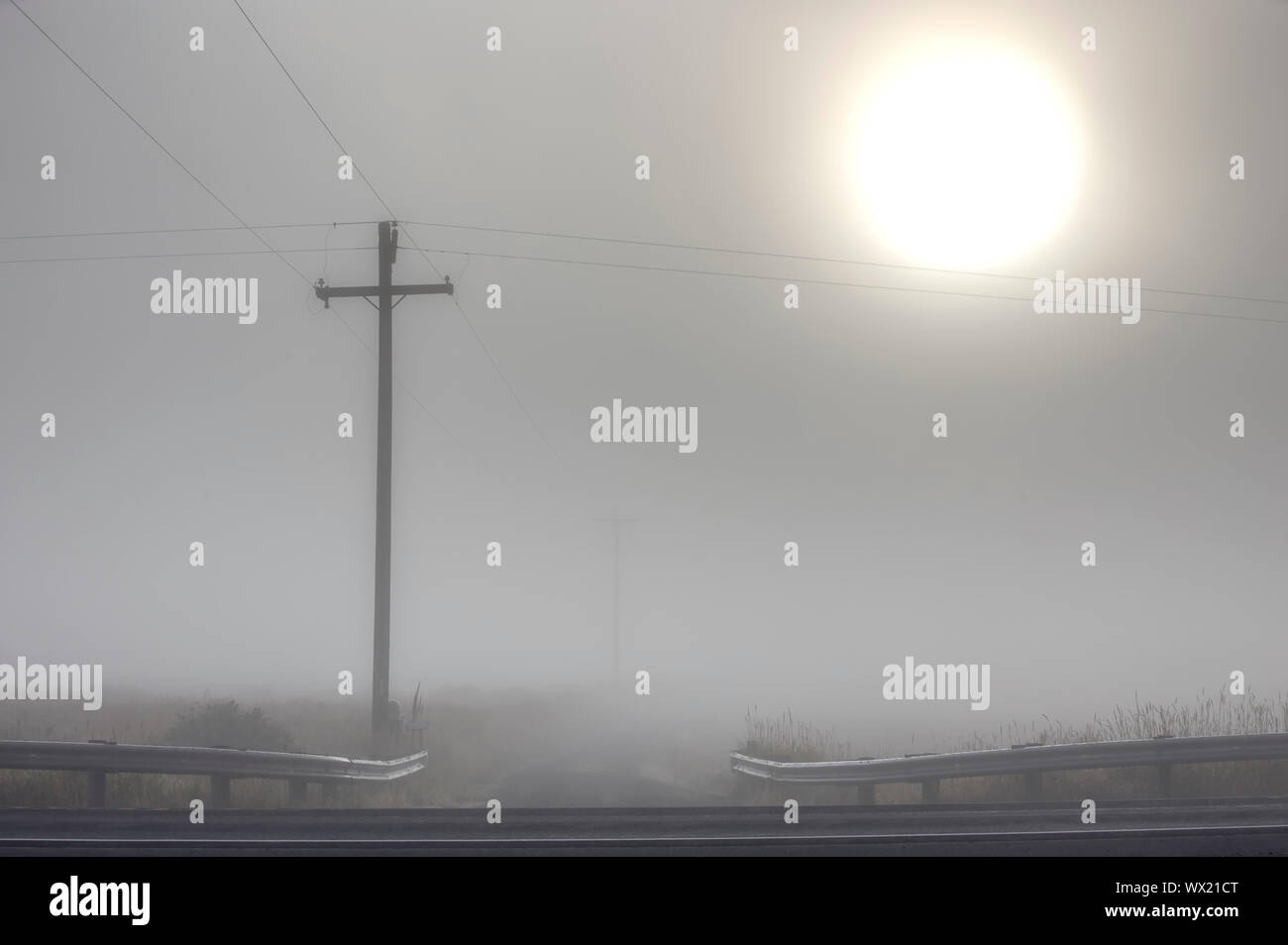 A photo of an early morning filled with fog at a country road in ...