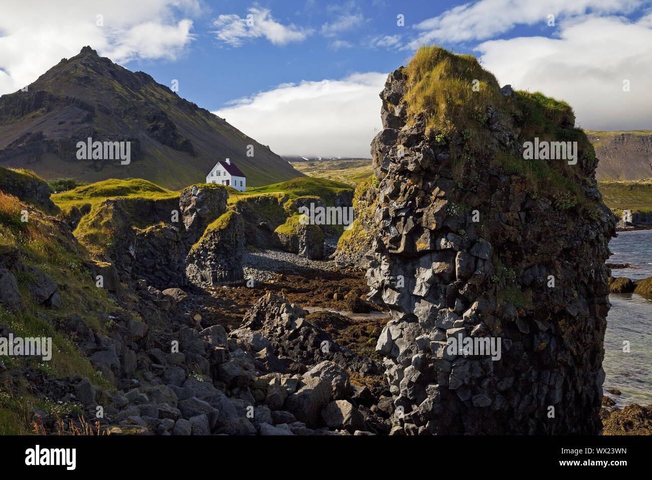 House on the basalt coast off Stapafell mountain, Arnarstapi ...