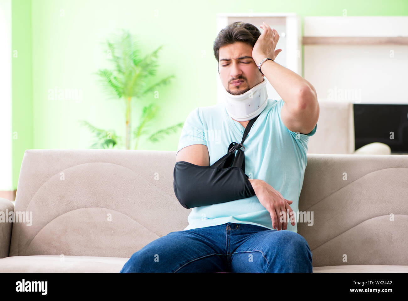 Young student man with neck and hand injury sitting on the sofa Stock ...