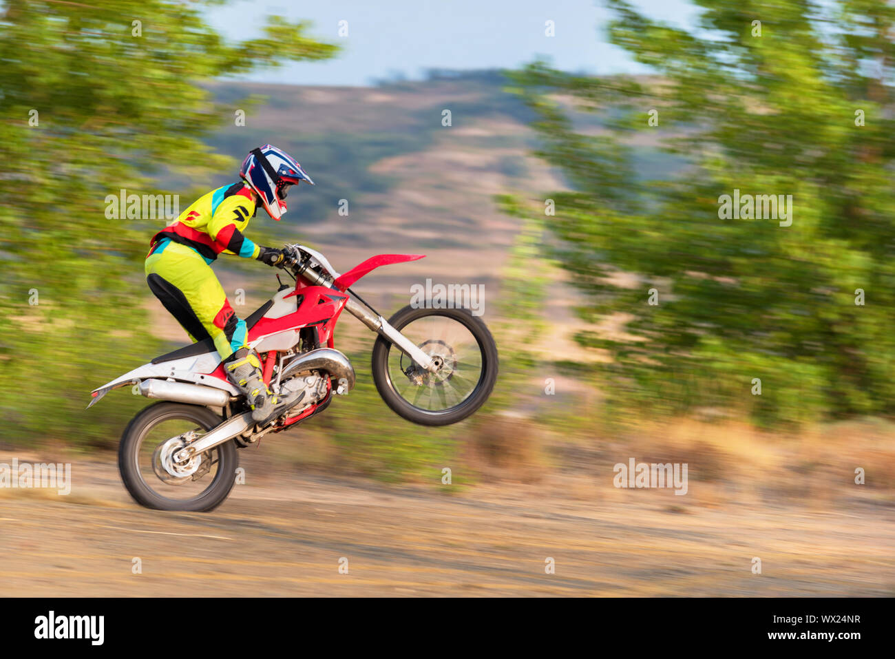 Motocross rider doing a wheelie Stock Photo - Alamy