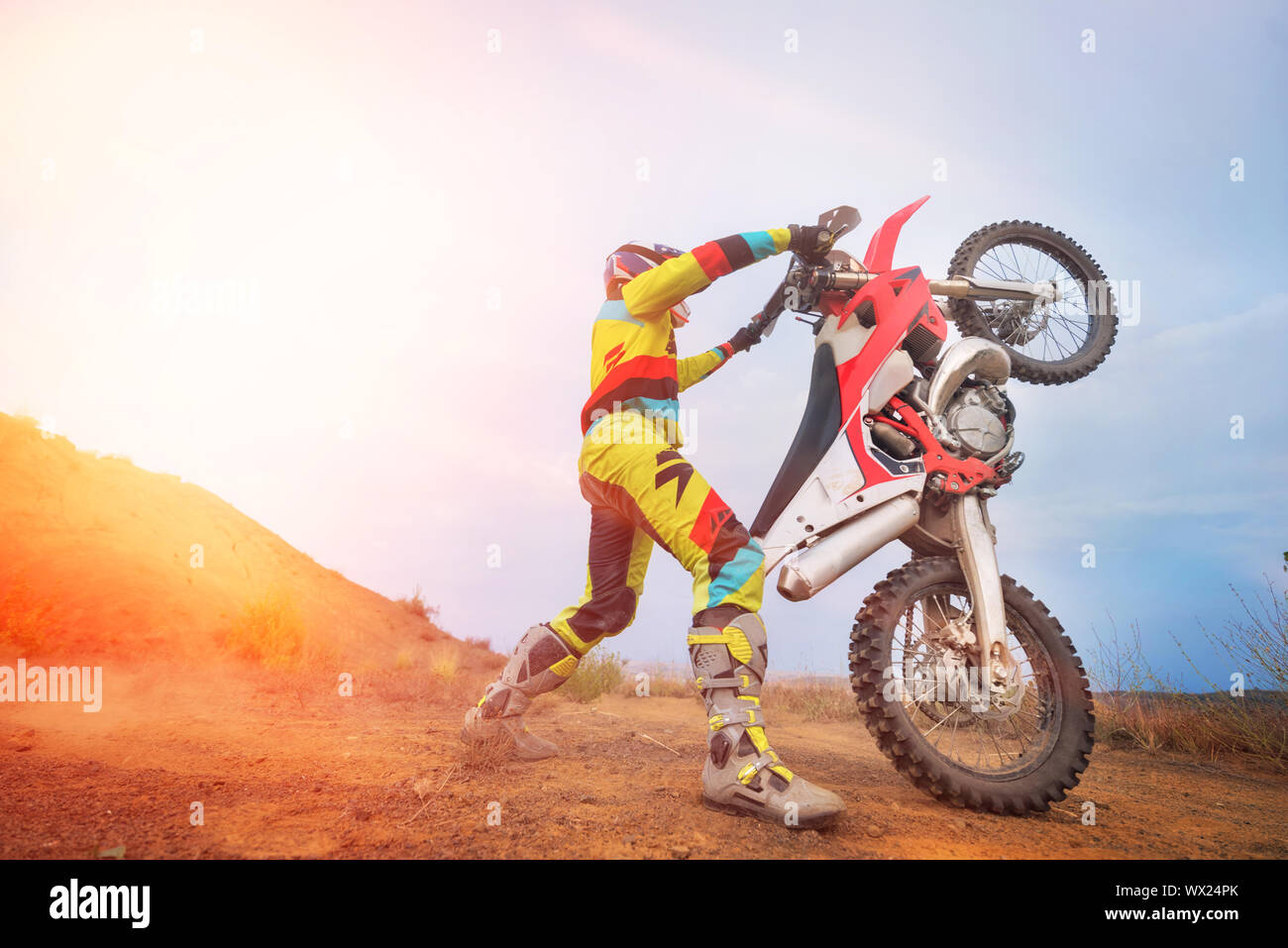 Motocross rider doing a wheelie Stock Photo - Alamy