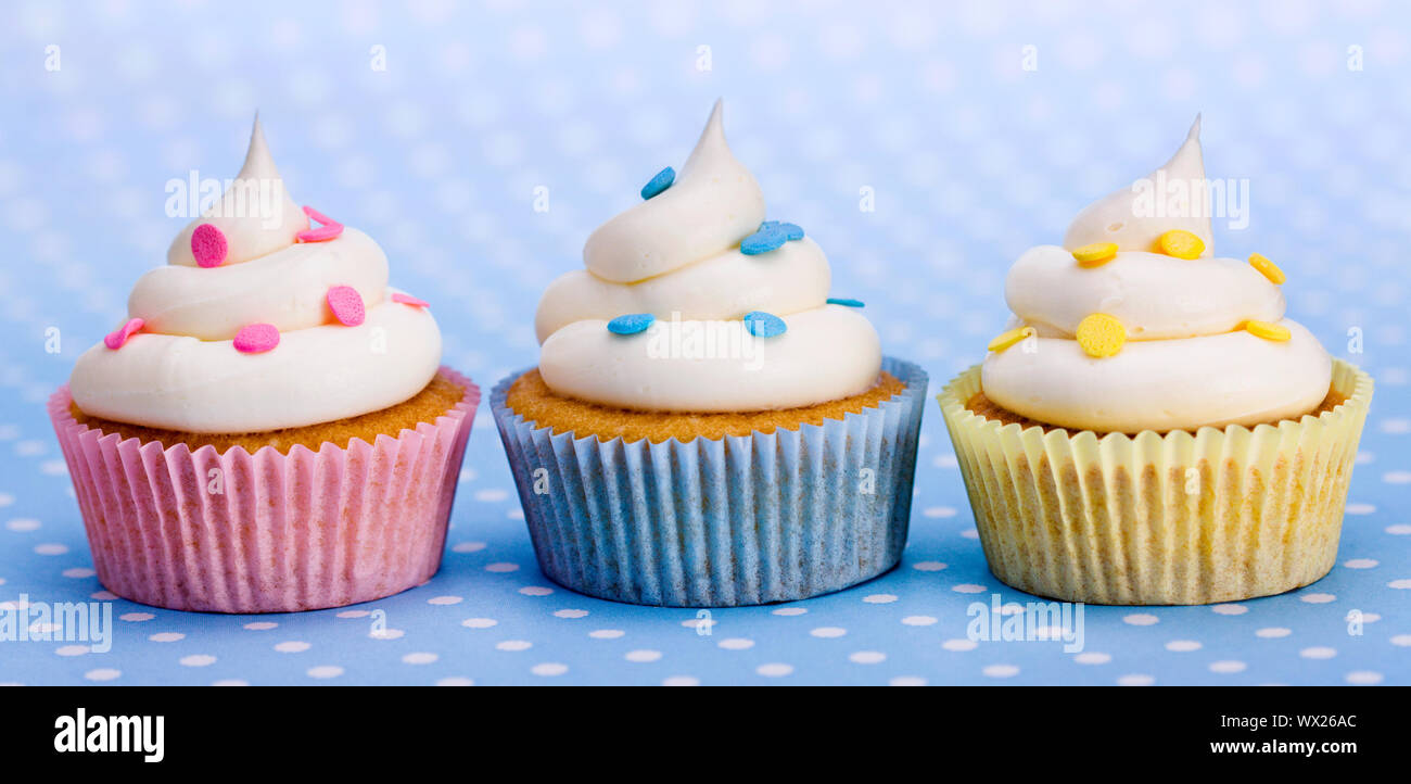 Pink, blue and yellow cupcakes in a row Stock Photo - Alamy