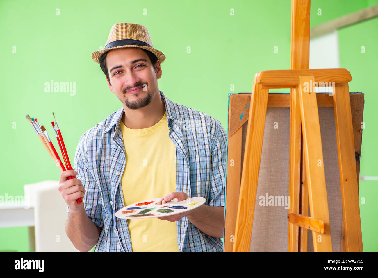 The young male artist working on new painting in his studio Stock Photo ...