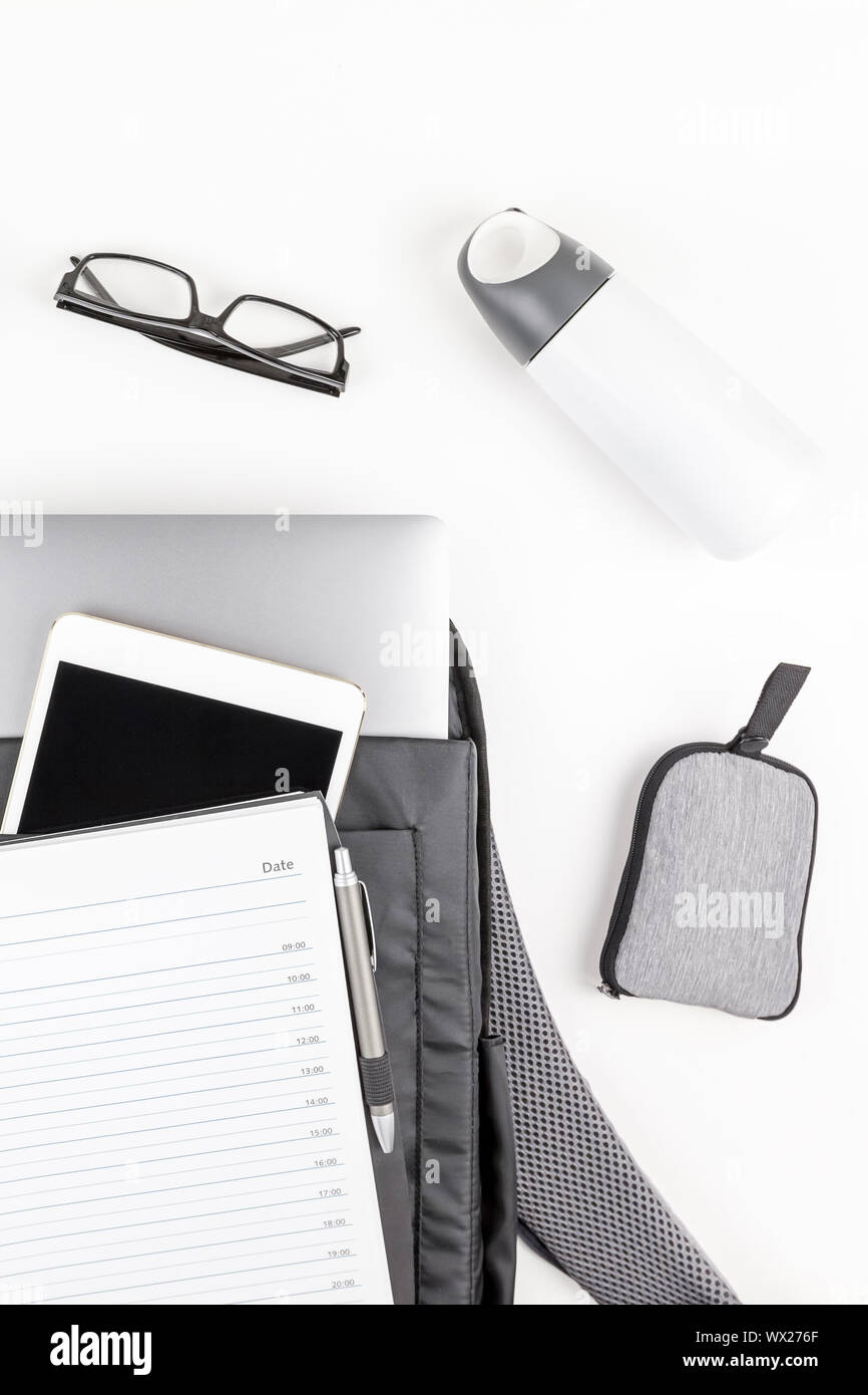 Creative top view flat lay of open backpack with laptop and tablet ...