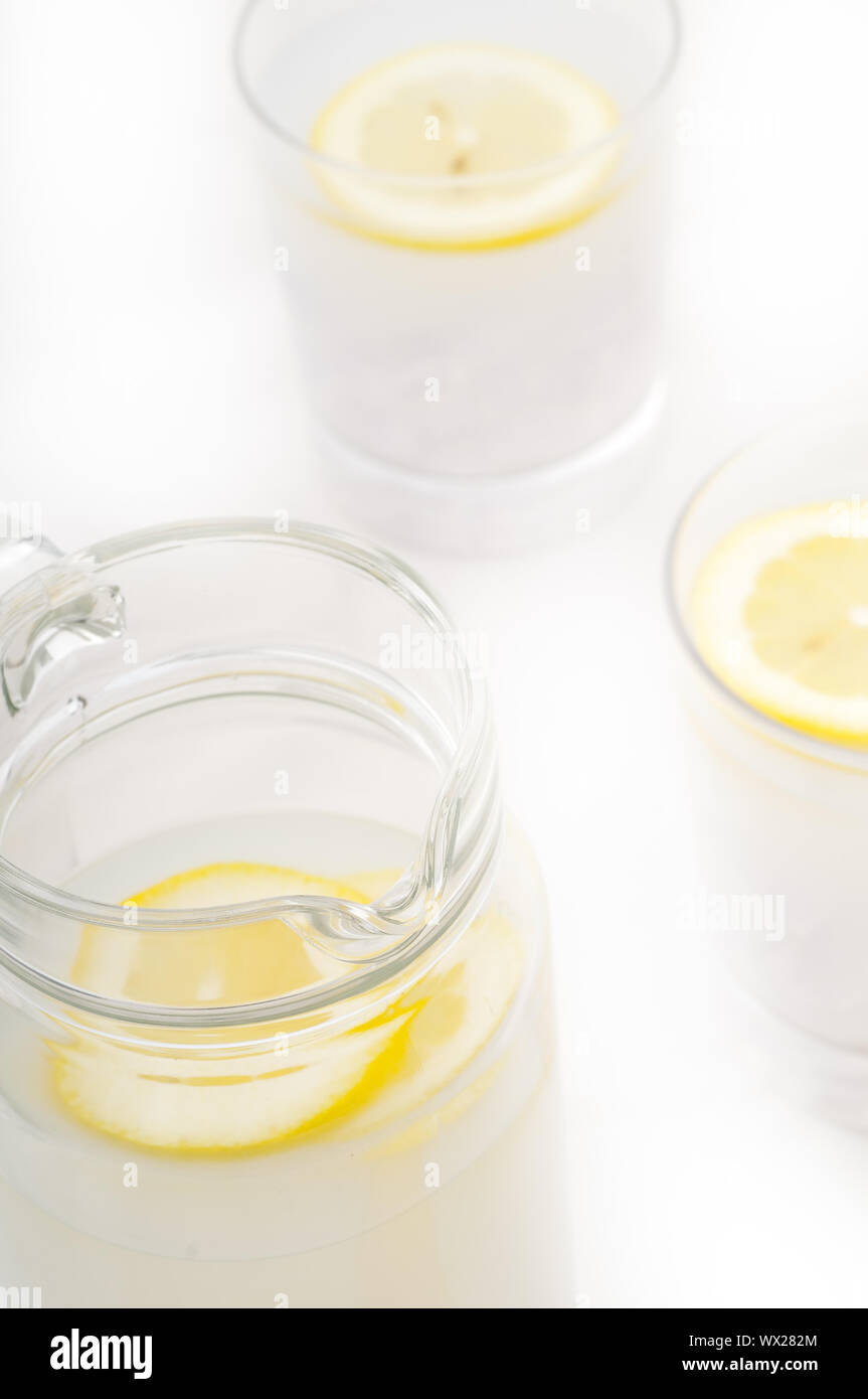 fresh lemonade drink with lemon slice closeup and pitcher carafe Stock ...