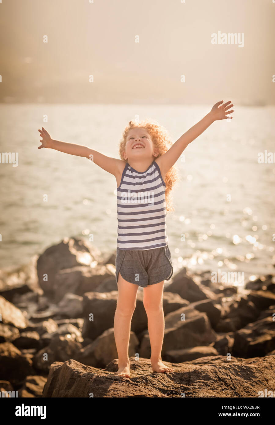 Little girl with raised hands Stock Photo - Alamy