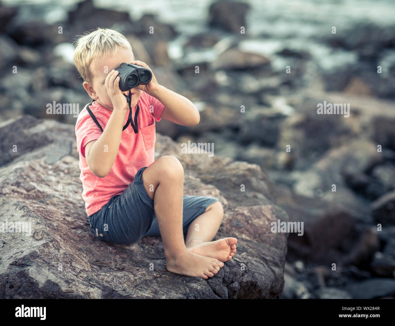 Little boy looking far away with binoculars Stock Photo - Alamy