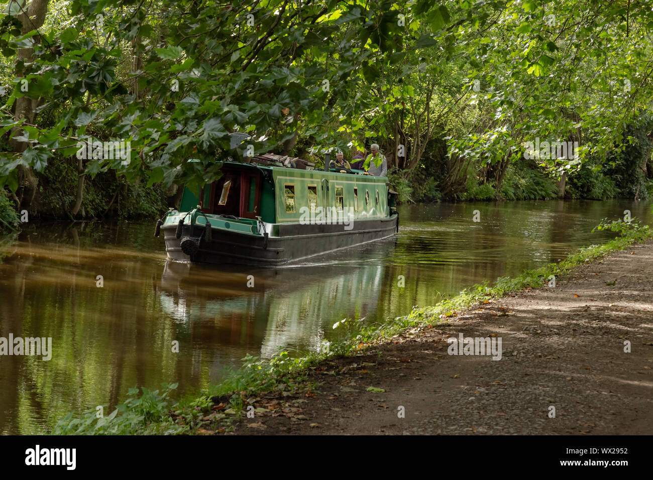 A barge floats on the Leeds Liverpool Canal in Saltaire, Yorkshire ...