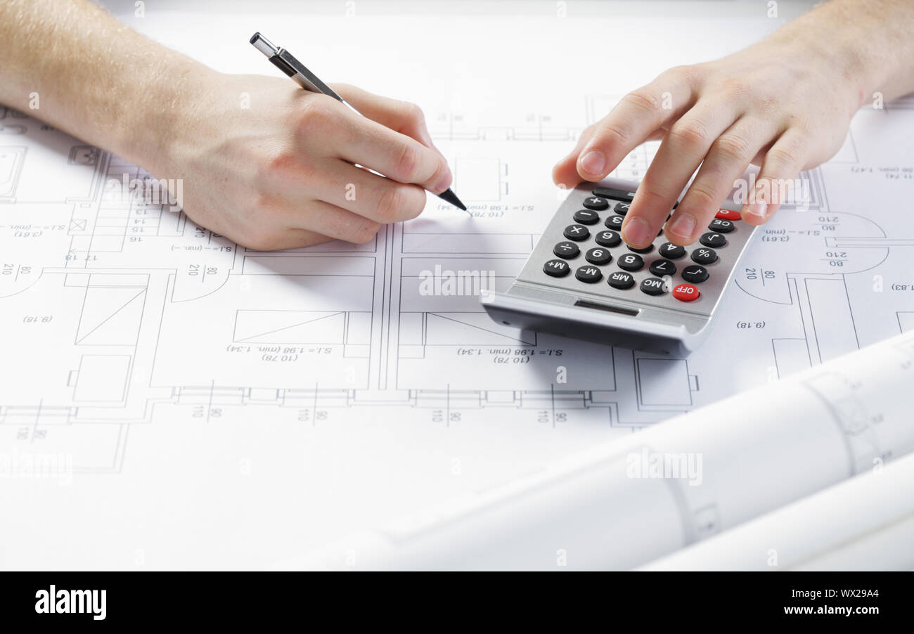 Architect reviewing a blueprint by adjusting the measurement with a pen ...