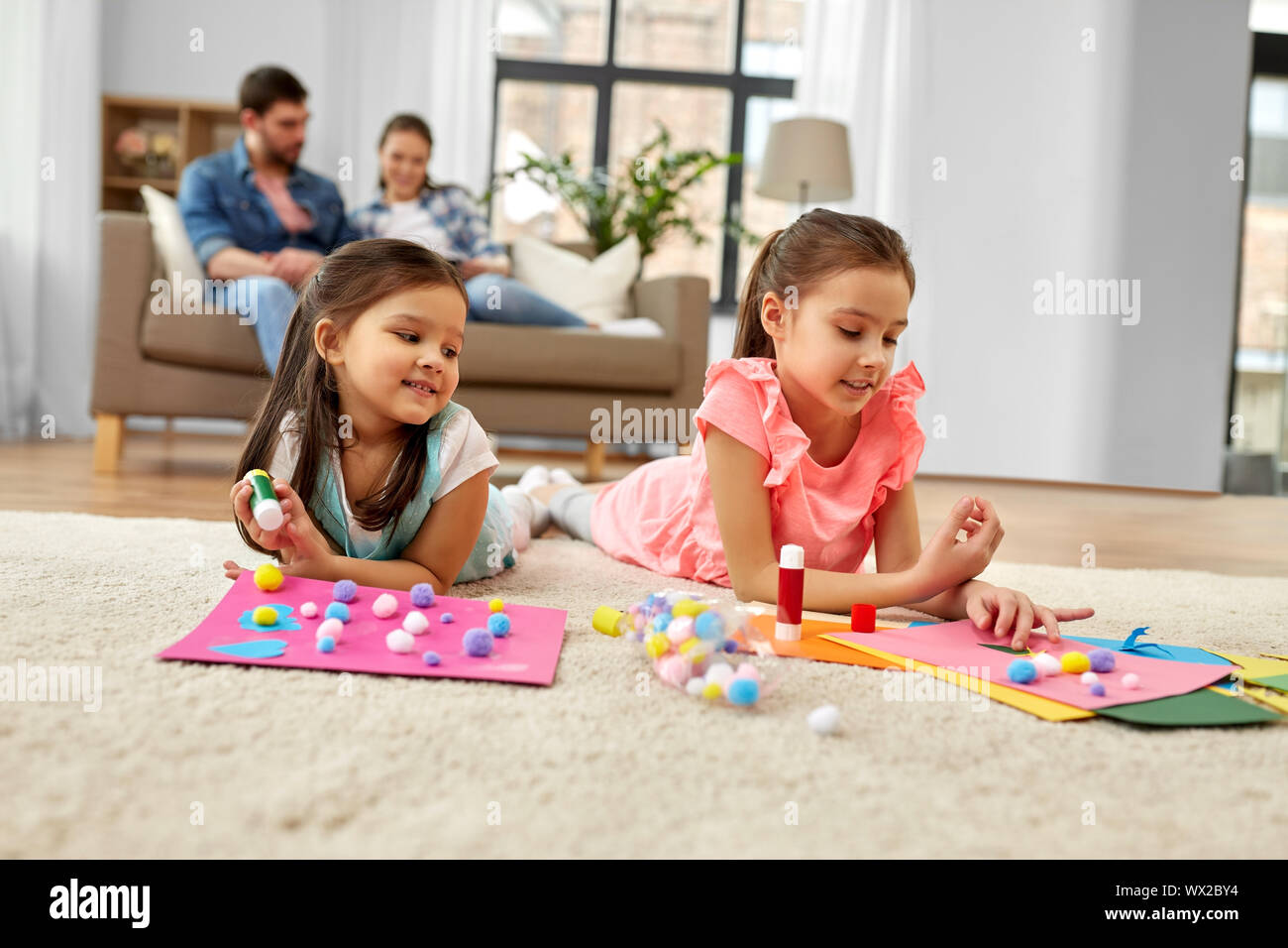 happy sisters doing arts and crafts at home Stock Photo - Alamy