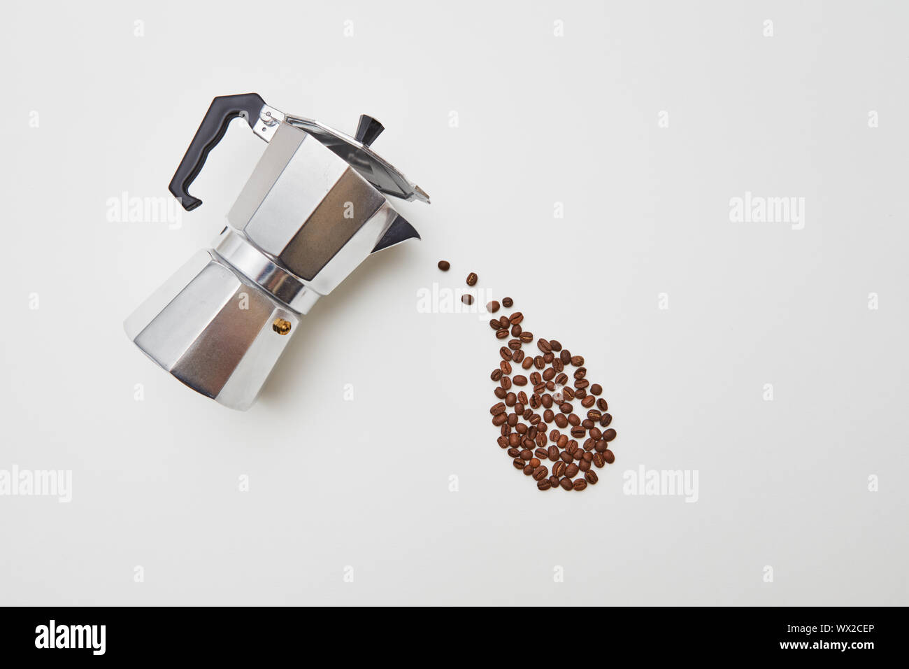 Coffee beans in the form of a drop dripping from a metal coffee maker ...