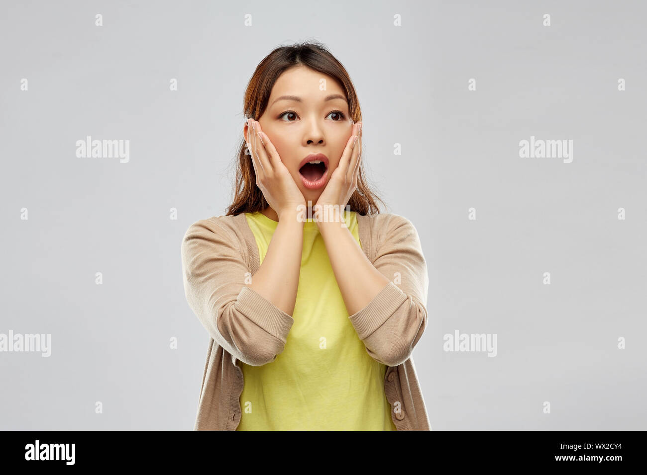 scared asian woman over grey background Stock Photo - Alamy