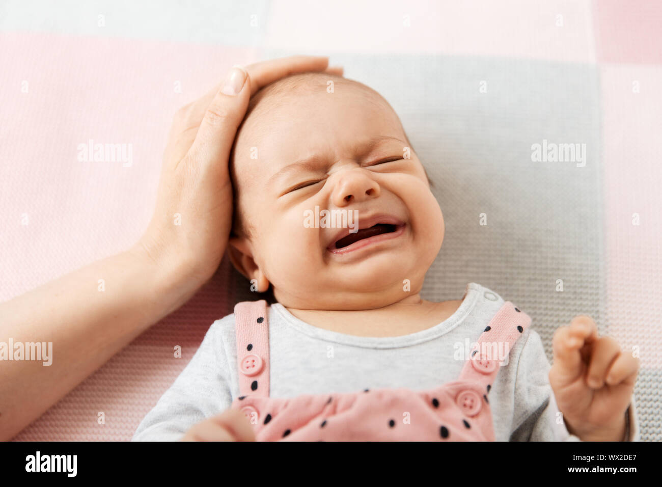 mother's hand touching crying little baby daughter Stock Photo - Alamy