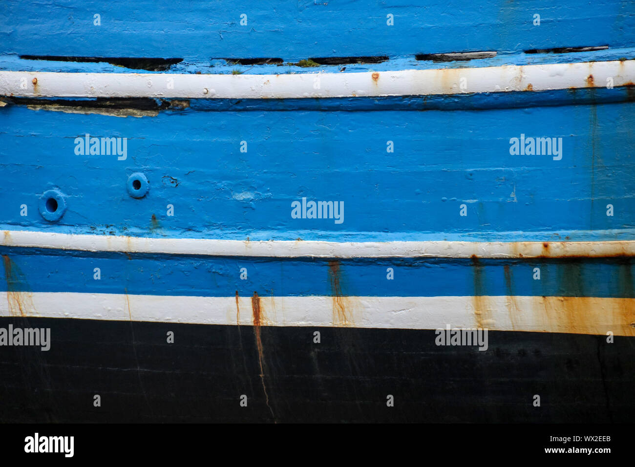 Close up side view of old abandoned blue painted boat Stock Photo - Alamy
