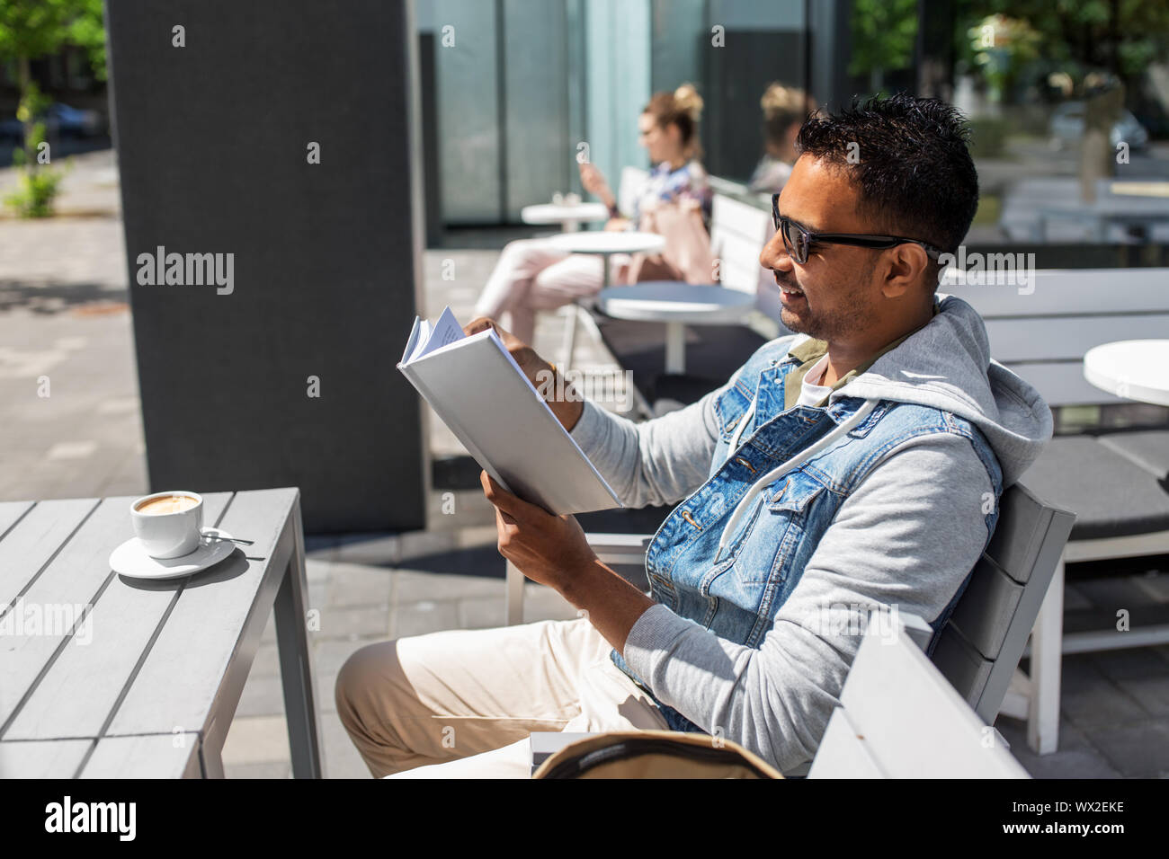 indian man reading book at street cafe Stock Photo - Alamy