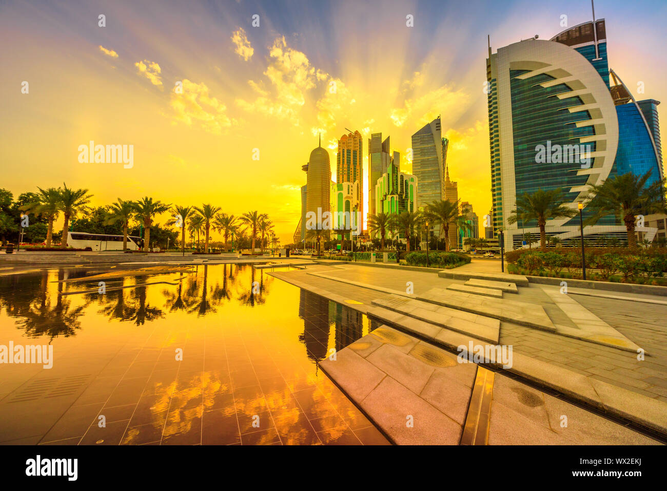 Scenic cityscape of Doha West Bay skyline at sunset light reflecting in ...