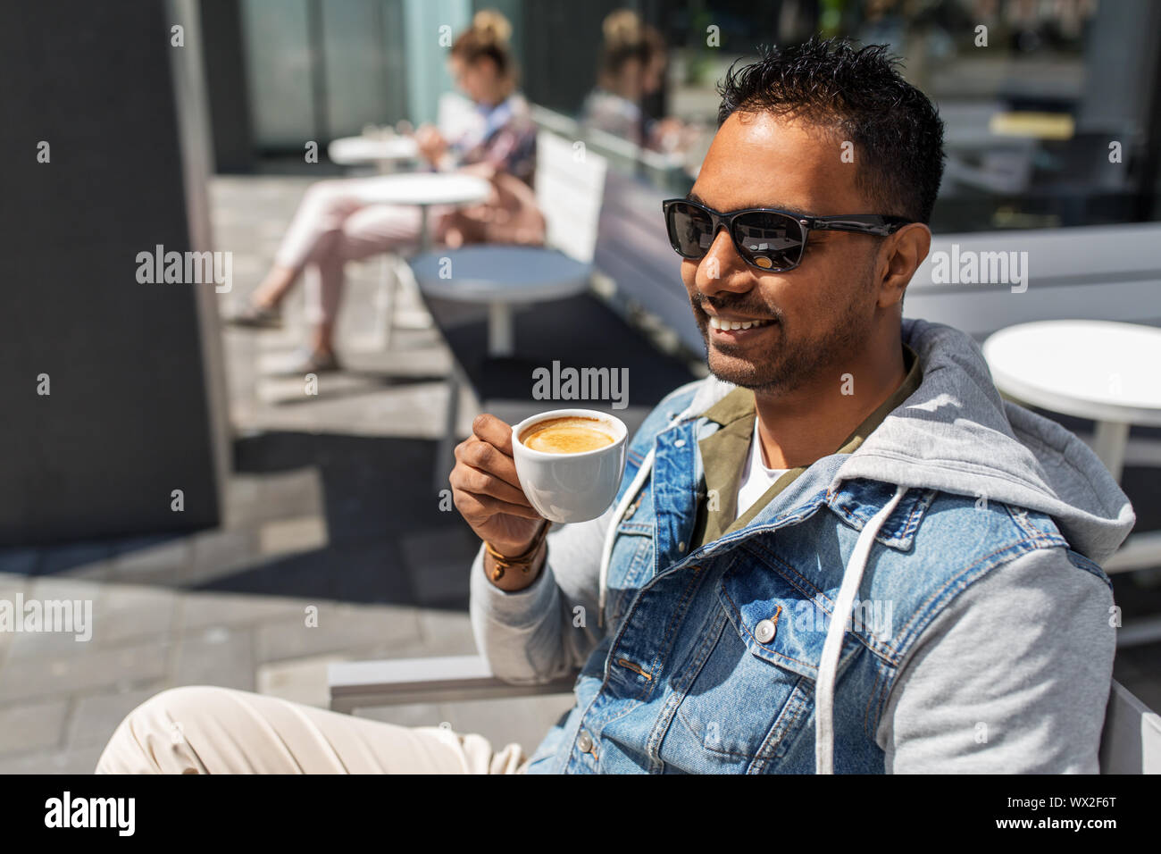 indian man drinking coffee at city street cafe Stock Photo - Alamy