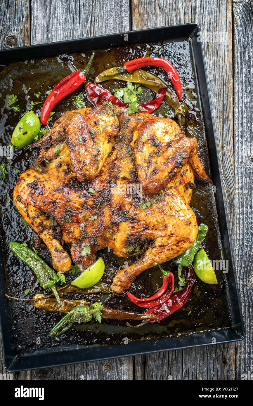 Spatchcocked barbecue chicken al mattone chili with lemon slices as top ...